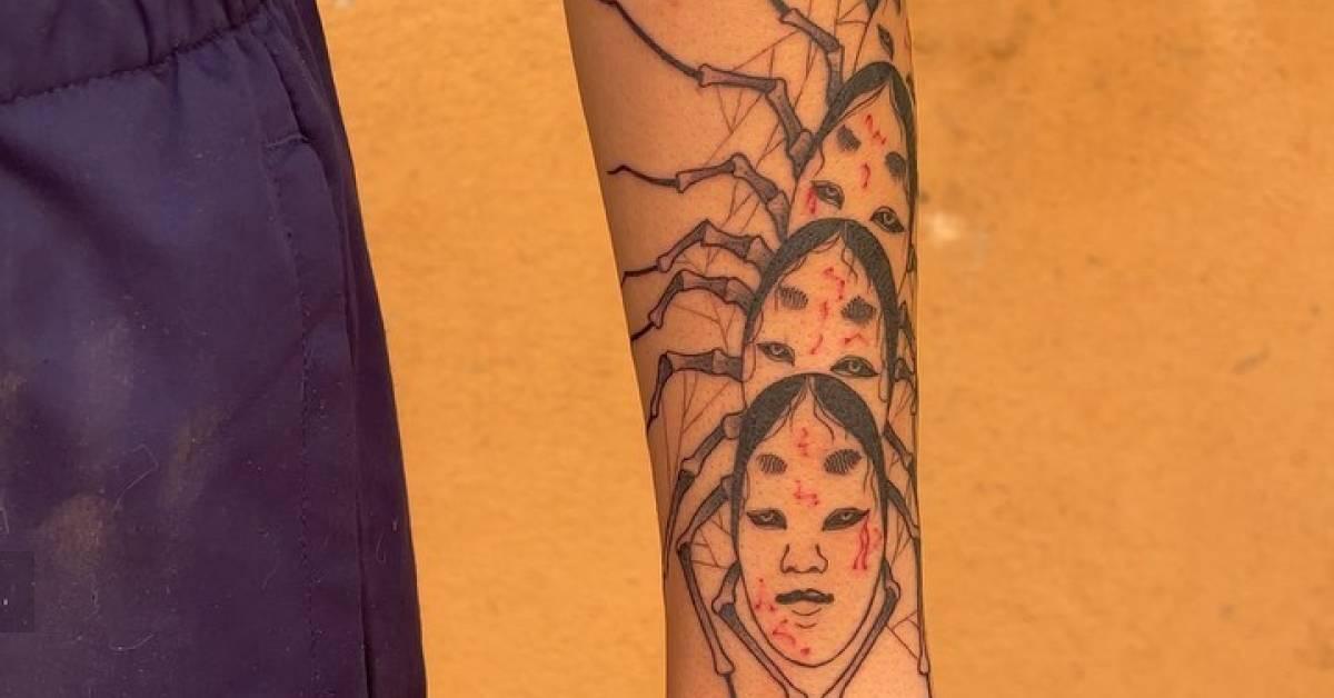 Noh mask centipede tattoo located on the forearm.