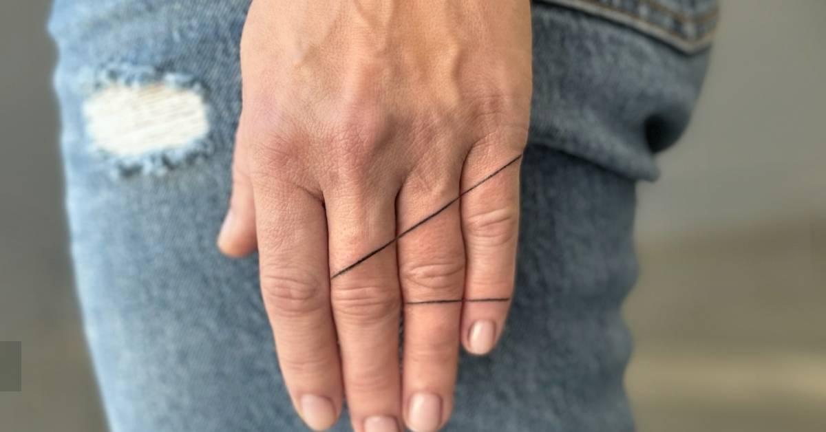 Lines tattoo located on the finger, geometric style.