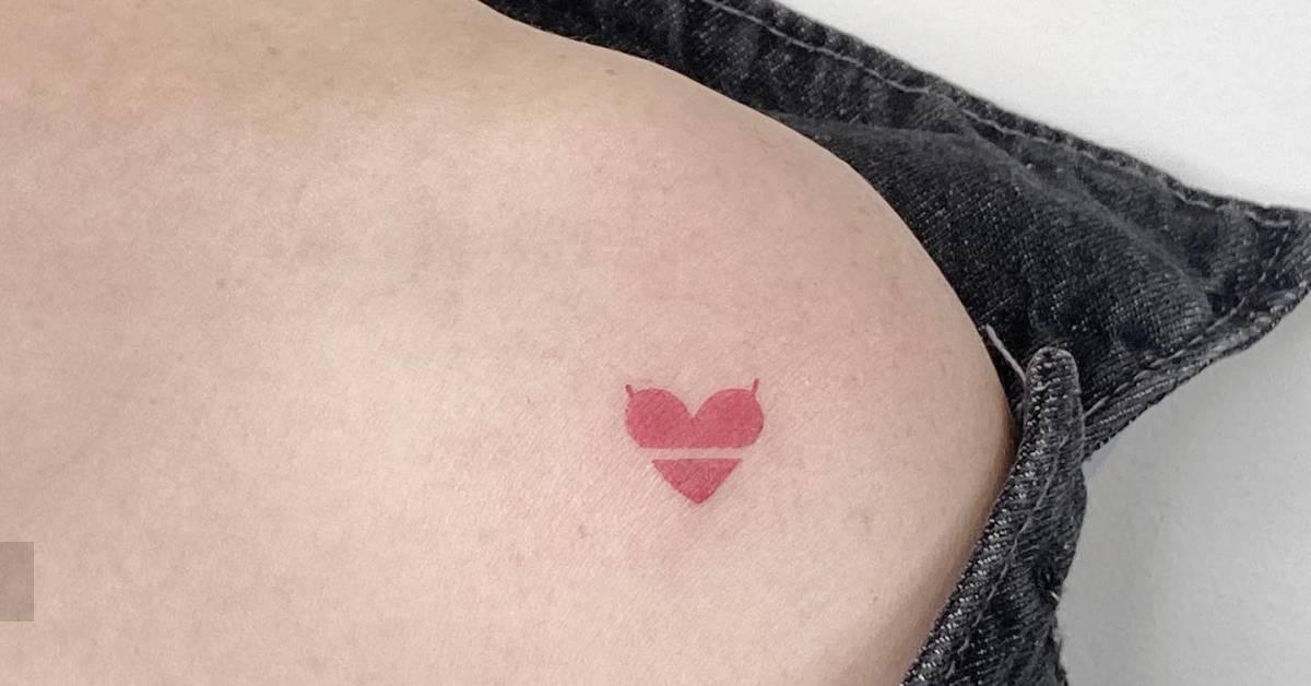 Red devil heart tattoo in minimalistic style located on