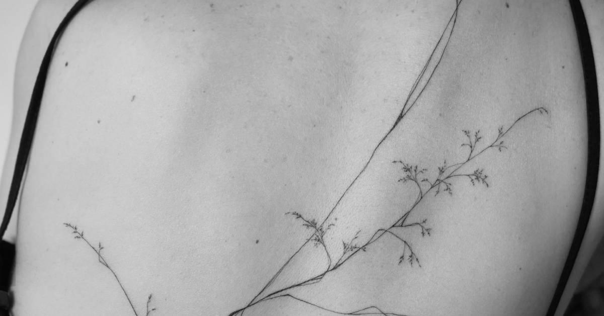 Illustrative style grass tattoo located on the back.