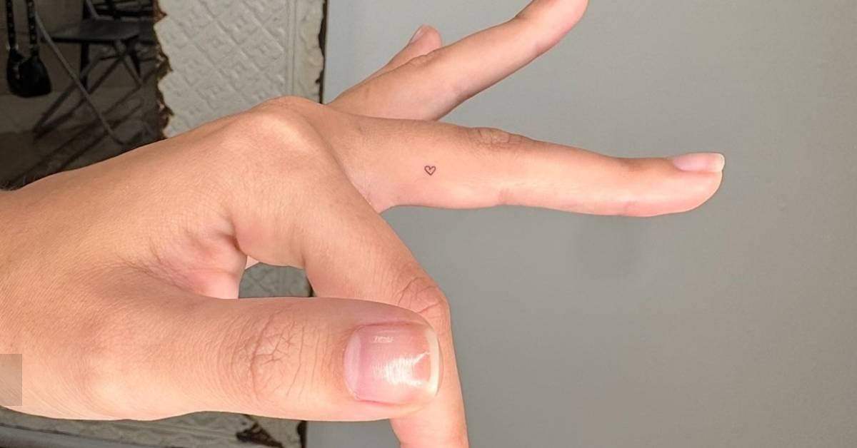 Tiny micro heart tattoo in minimalistic style done on