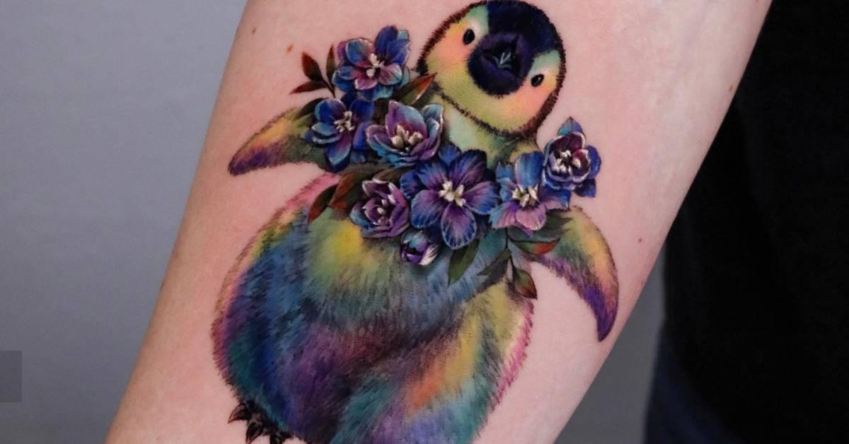 Cute penguin tattoo in realistic style placed on the