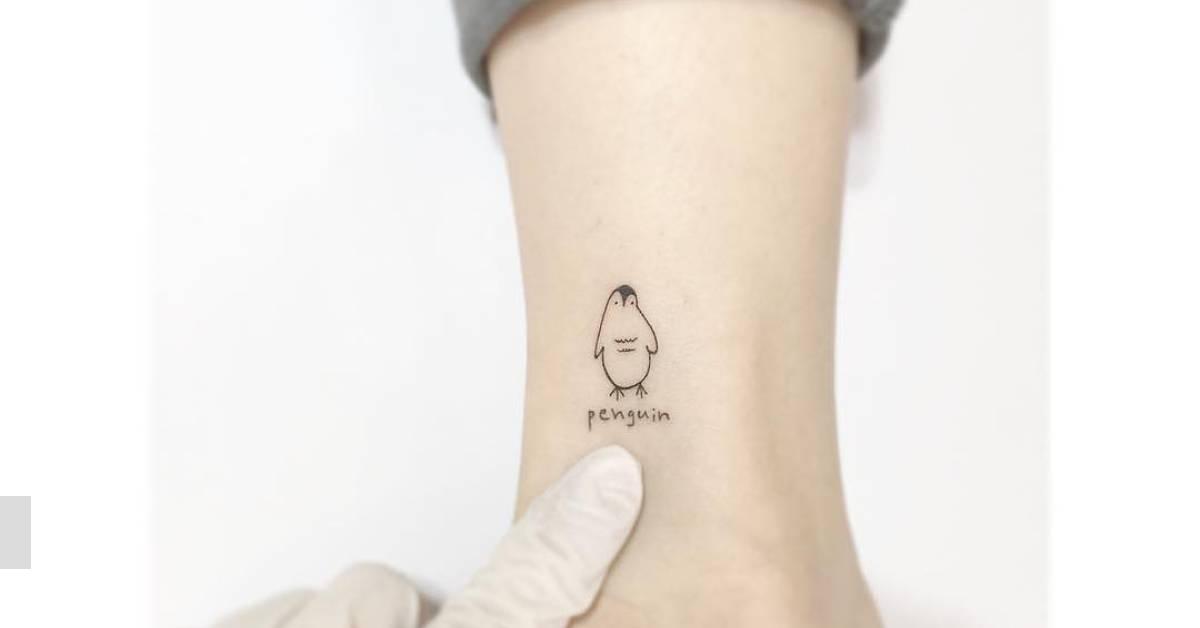 Minimalistic style penguin tattoo located on the ankle.
