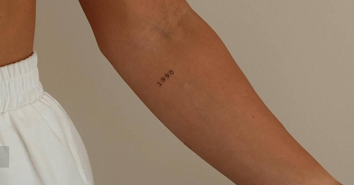 Birth year "1990" lettering tattoo in typewriter font