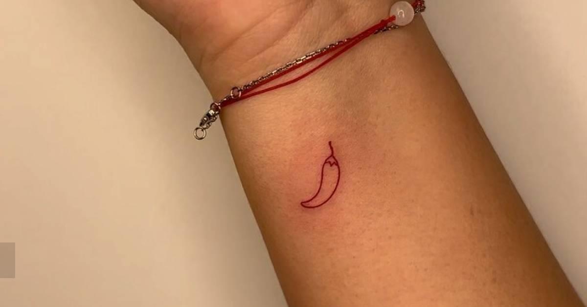 Minimalistic red chilli tattoo located on the chili.