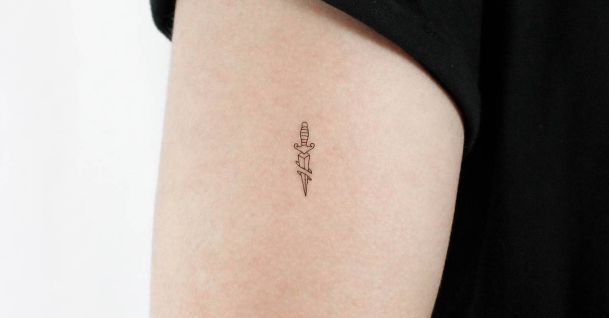 Little fine line style dagger temporary tattoo located