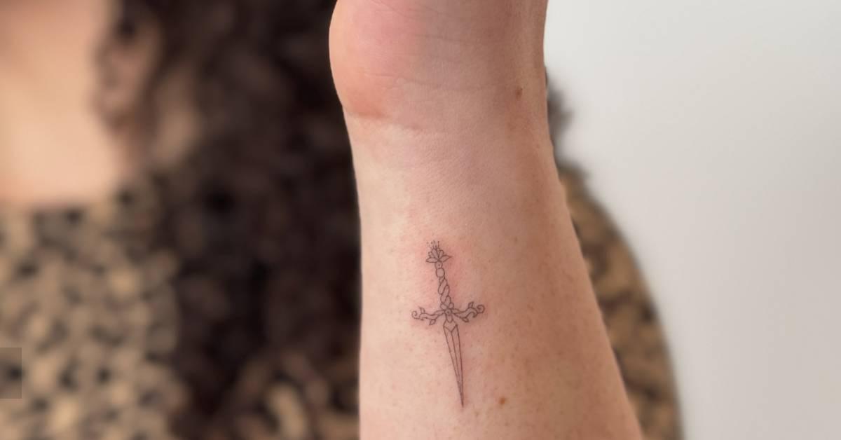 Little dagger tattoo in fine line style placed on the