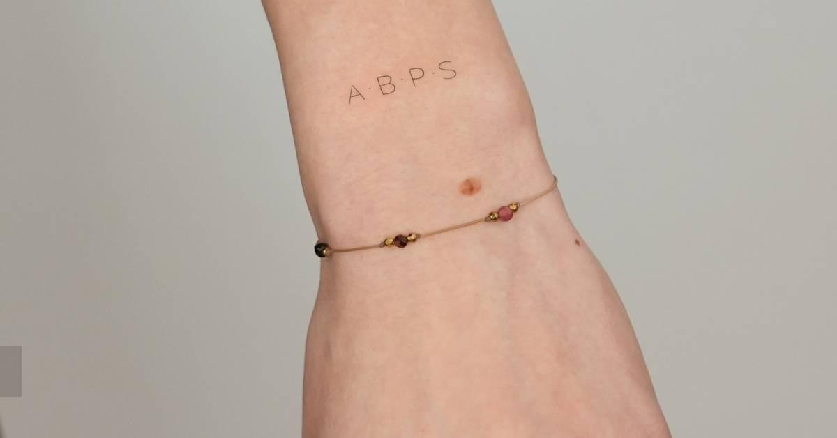 Minimalistic style initials tattoo located on the