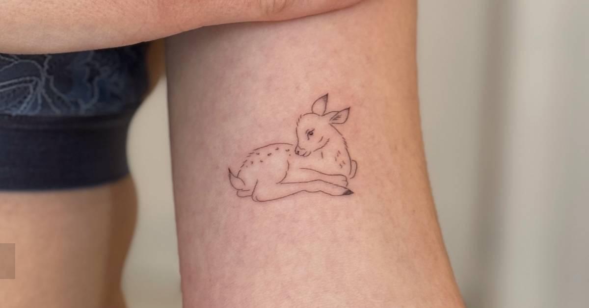Fine line style fawn tattoo located on the bicep.