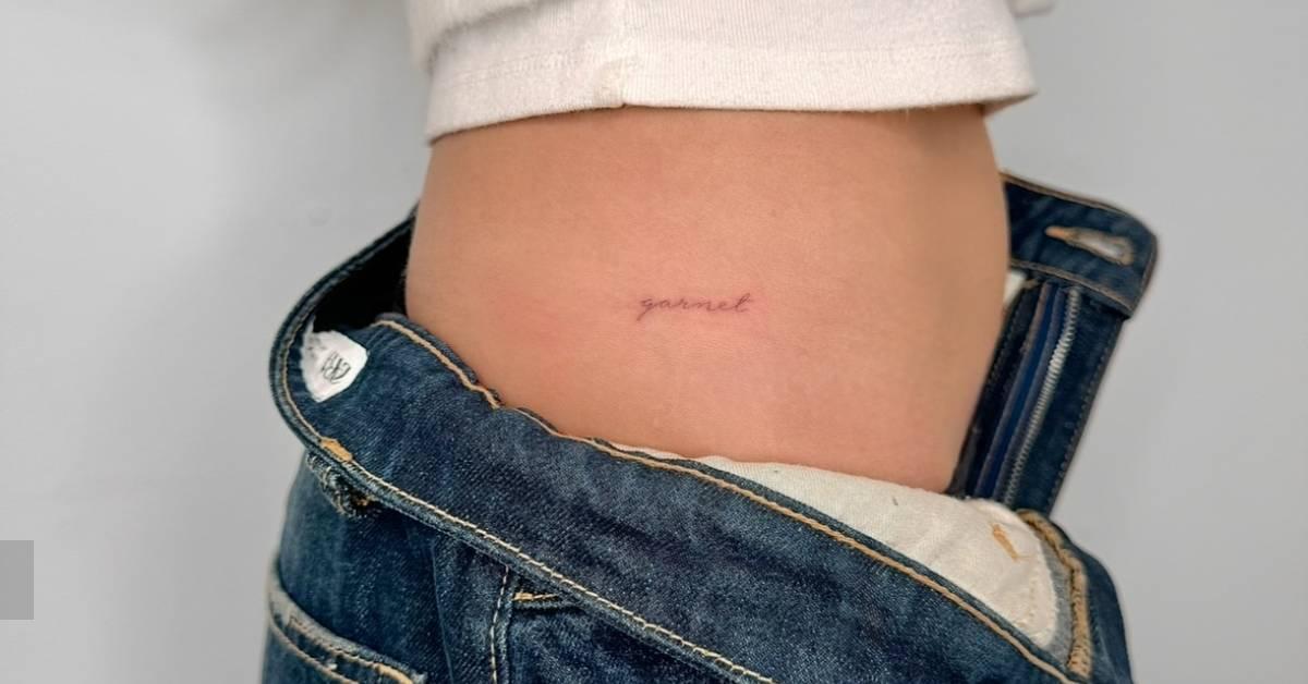 "Garnet" handwritten lettering tattoo located on the