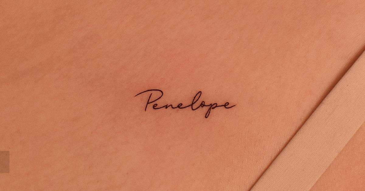"Penelope" lettering tattoo located on the chest.