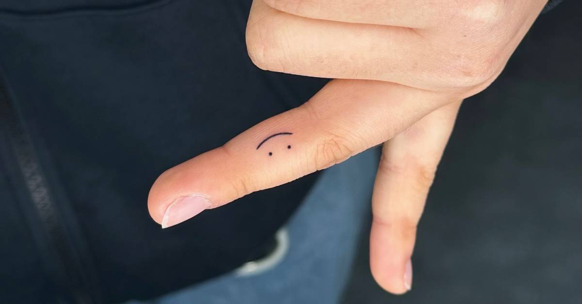 Hand poked little smiley face tattoo done on the