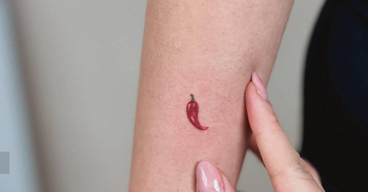 Illustrative style red chili tattoo located on the