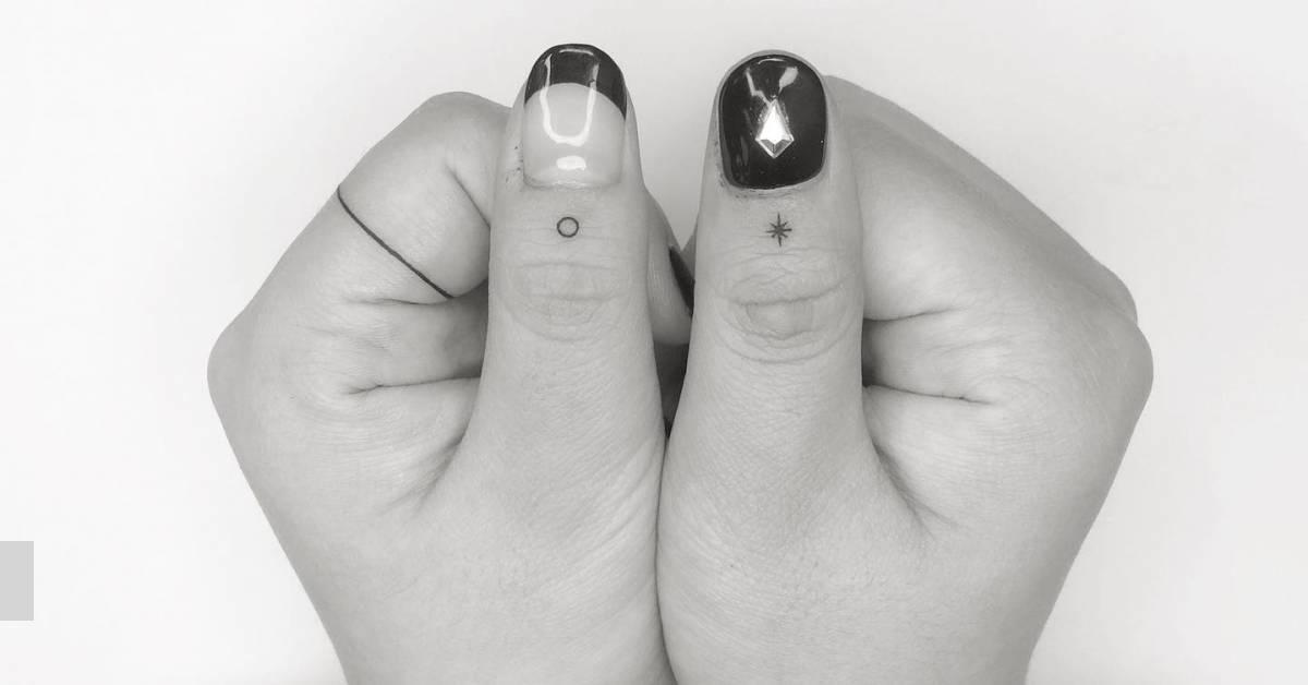 Tiny matching circle and star tattoos located on the