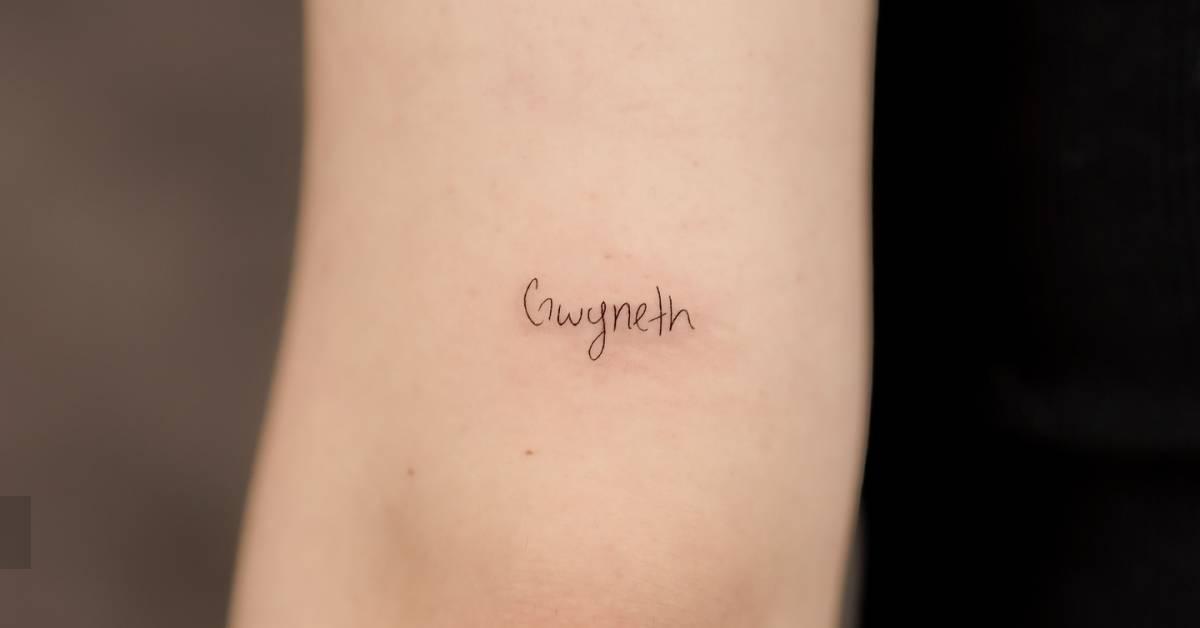 "Gwyneth" handwritten lettering tattoo located on the