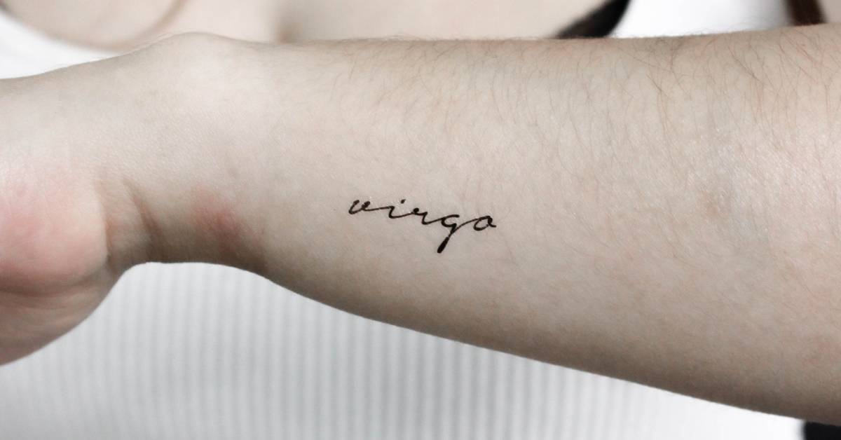 Handwritten word "Virgo" temporary tattoo placed on the