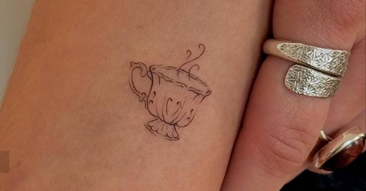 Fine line style teacup tattoo located on the wrist.