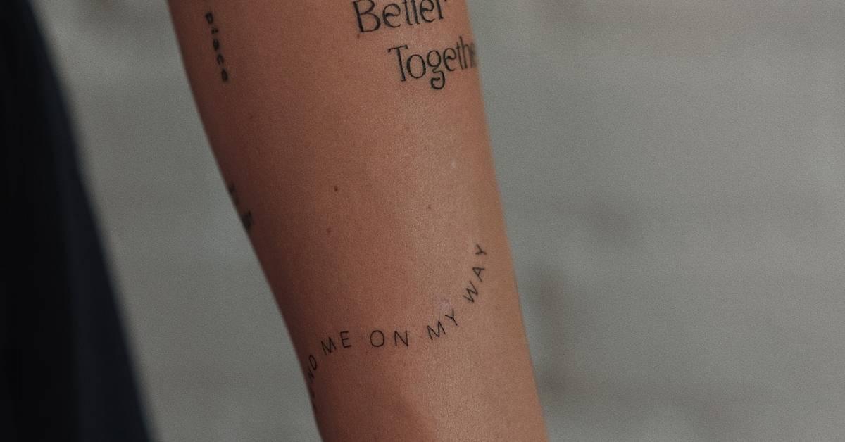 Lettering style forearm composition tattoos.