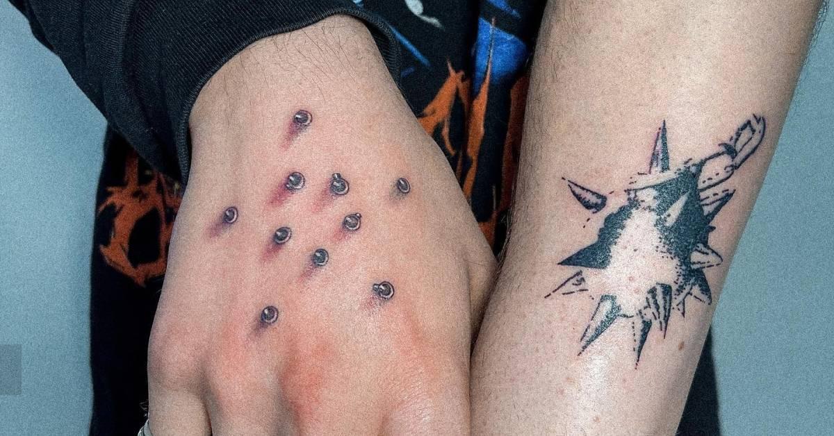 Surface piercings and flail tattoo located on the hand