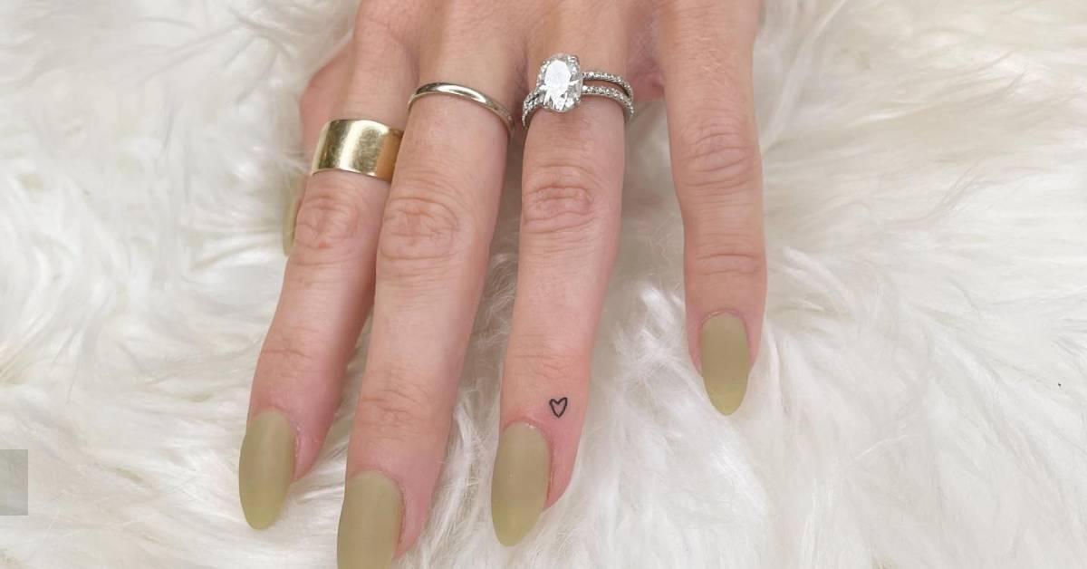 Micro heart tattoo located on the finger.
