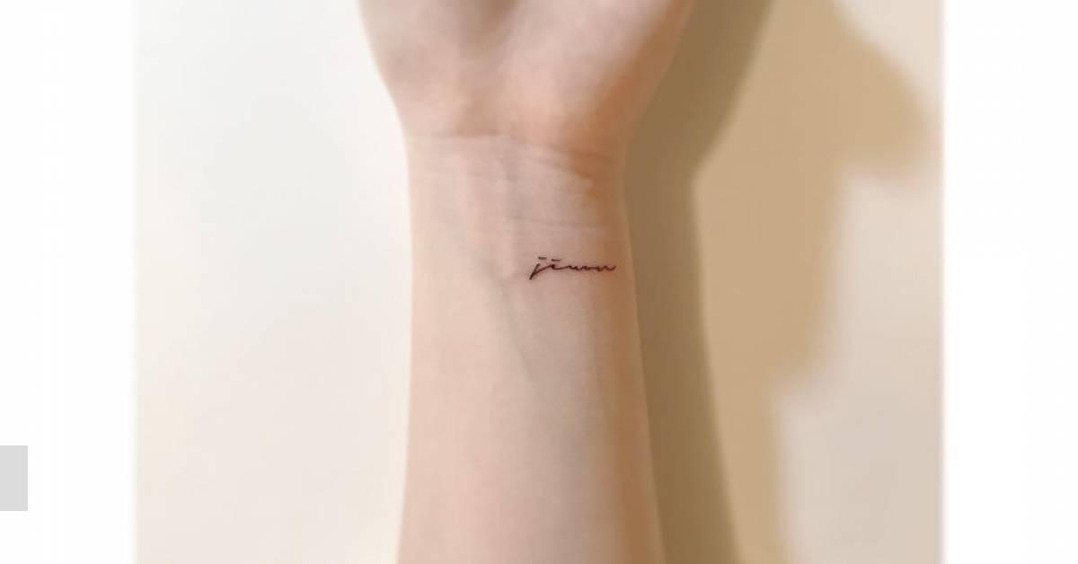 Tiny name tattoo in handwritten font located on the