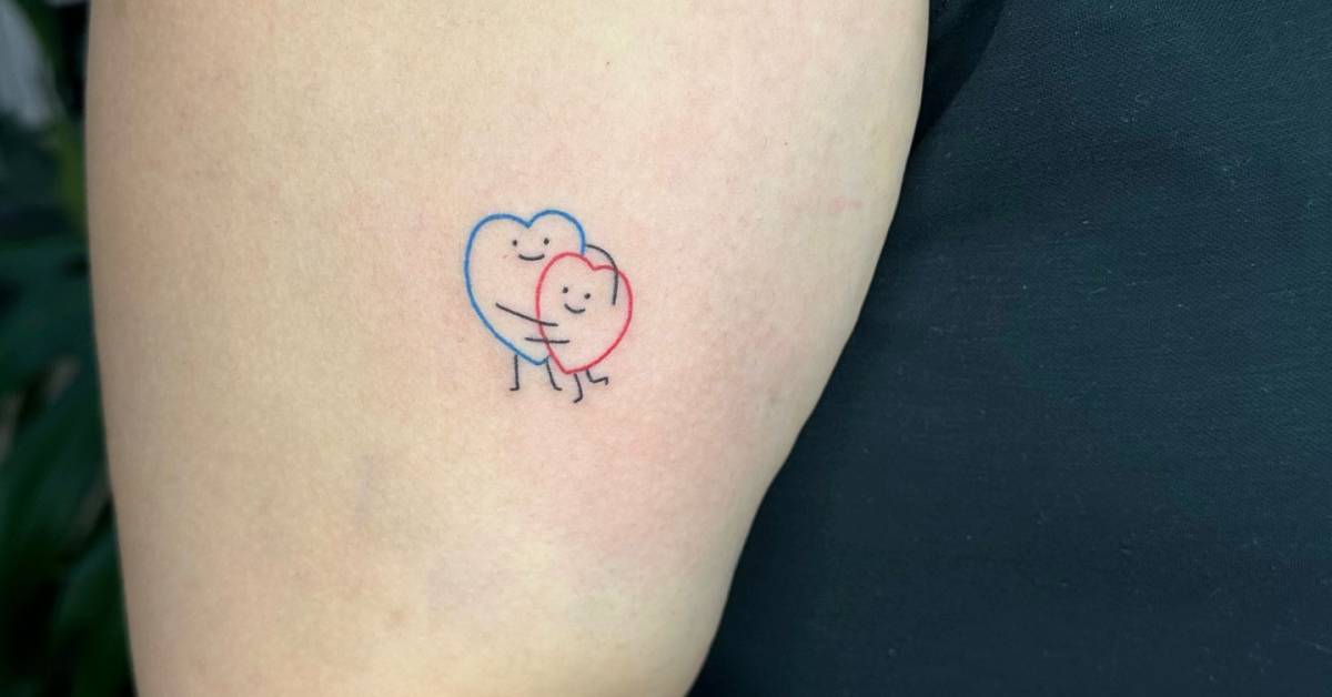 Hearts hugging tattoo located on the upper arm.