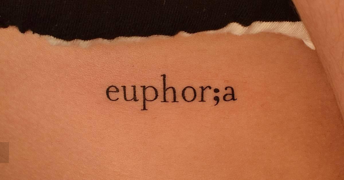 Lettering tattoo of the word "euphoria" located on the