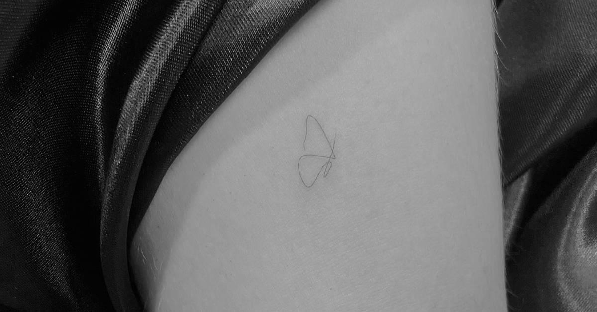 One line butterfly tattoo located on the inner arm.