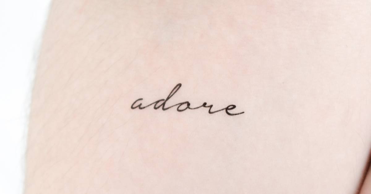Word "adore" in handwritten font temporary tattoo