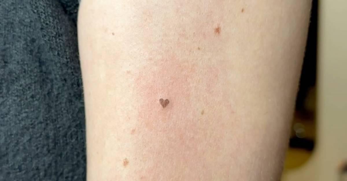 Minimalistic style freckle heart tattoo located on the