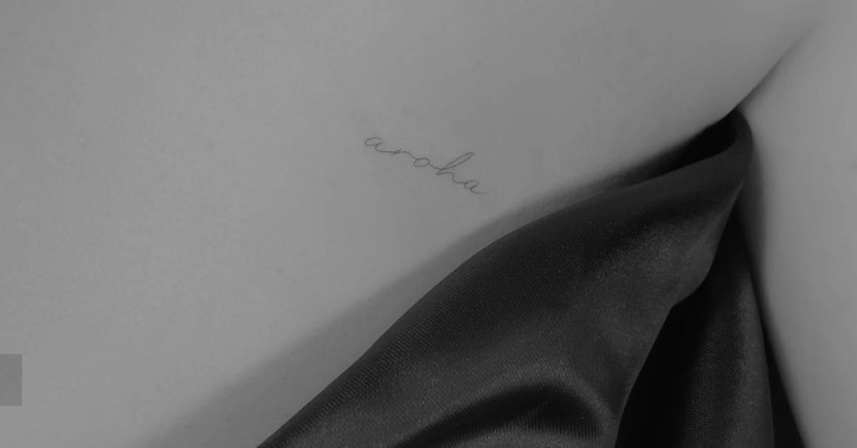 "Aroha" handwritten lettering tattoo located on the