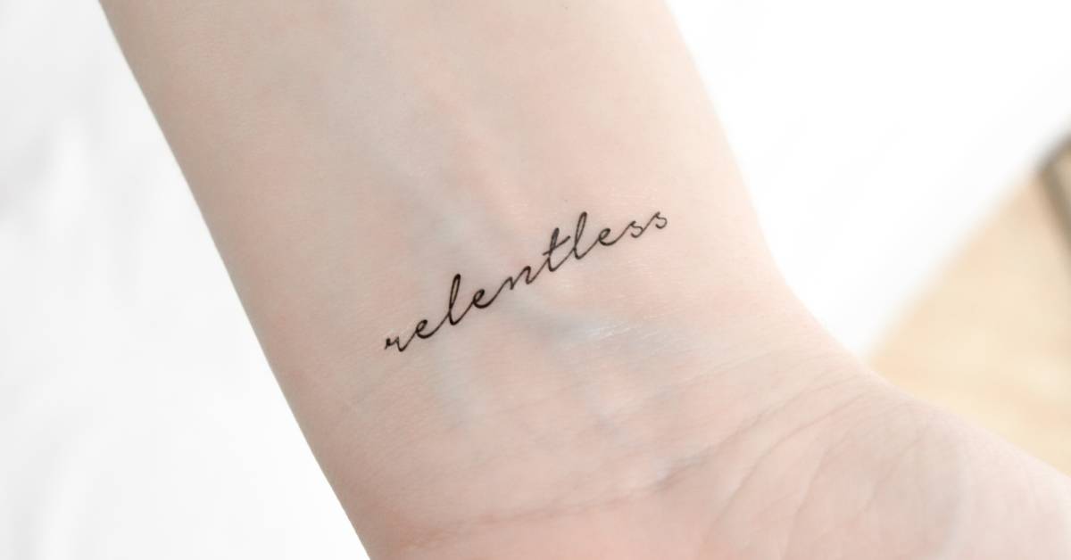 Handwritten word "relentless" temporary tattoo placed