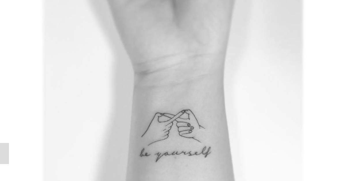 Hands making infinity symbol tattooed on the wrist,