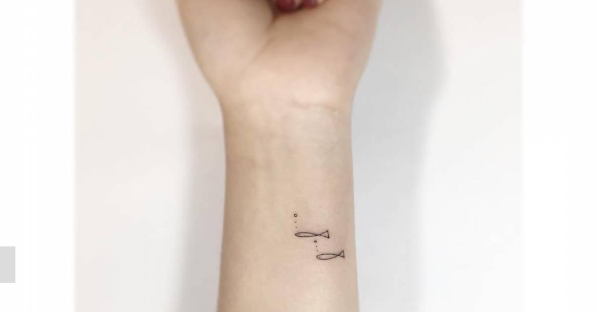 Tiny minimalistic fish tattoo placed on the wrist.