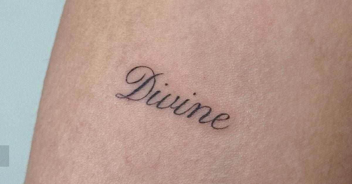 Word "Divine" lettering tattoo located on the inner
