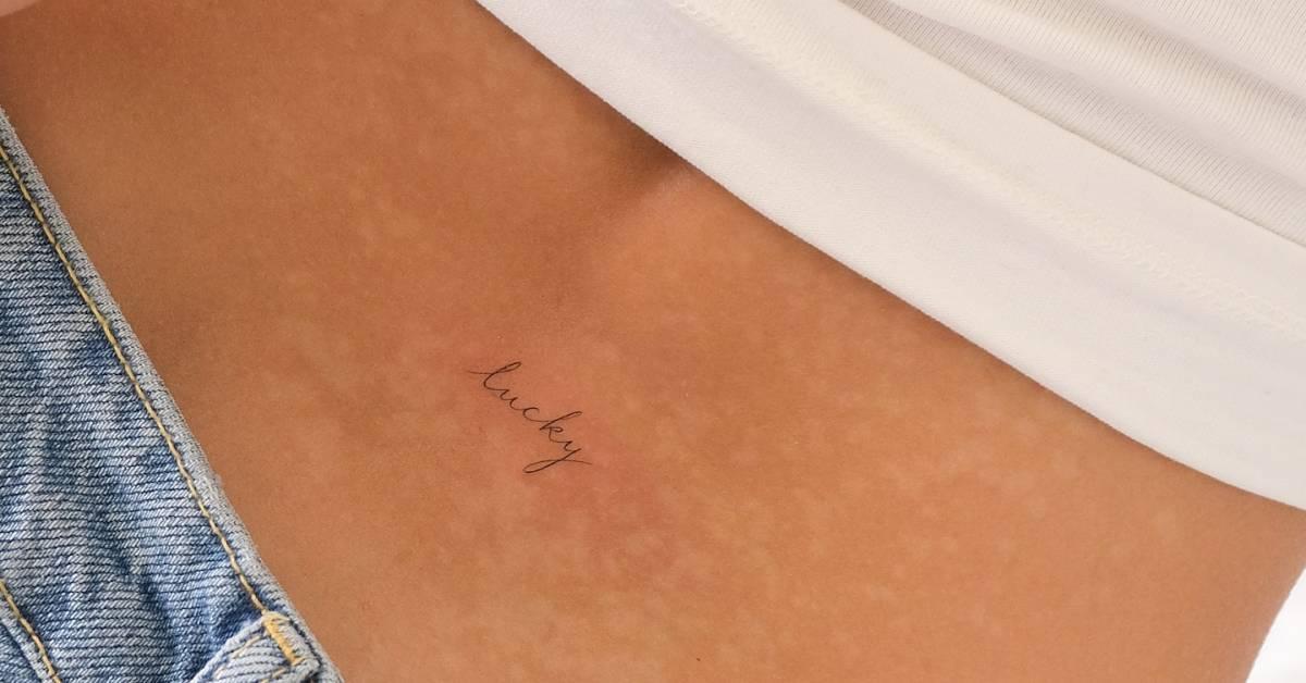 Handwritten word "lucky" lettering tattoo located on
