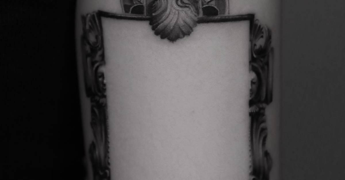 Blackwork style frame tattoo located on the tricep.