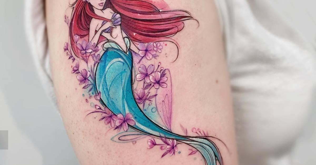 Cartoon style Ariel tattoo located on the upper arm.
