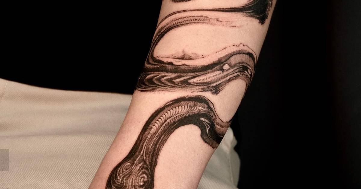 Blackwork style snake tattoo placed on the forearm.