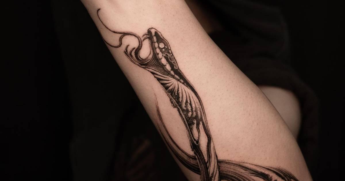 Blackwork style snake tattoo placed on the forearm.