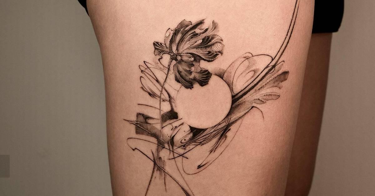 Abstract style flower tattoo located on the thigh.