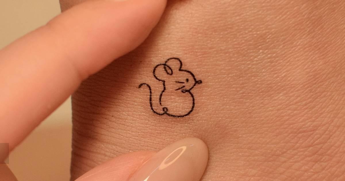 Tiny minimalistic mouse tattooed on the ankle.
