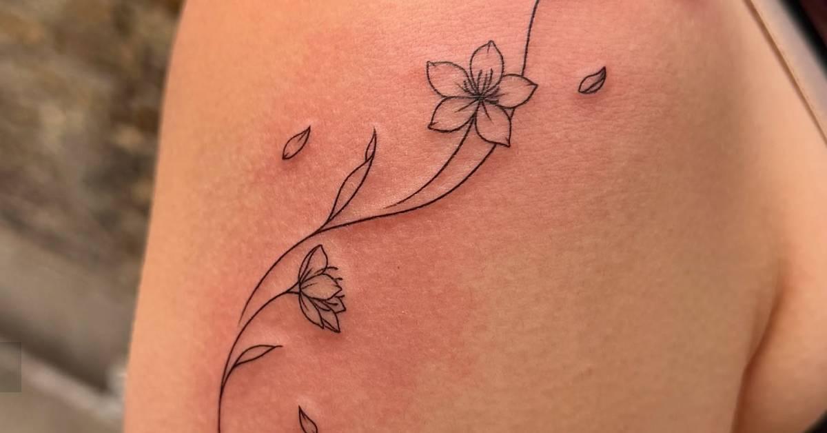 Fine line style cherry blossom tattoo located on the