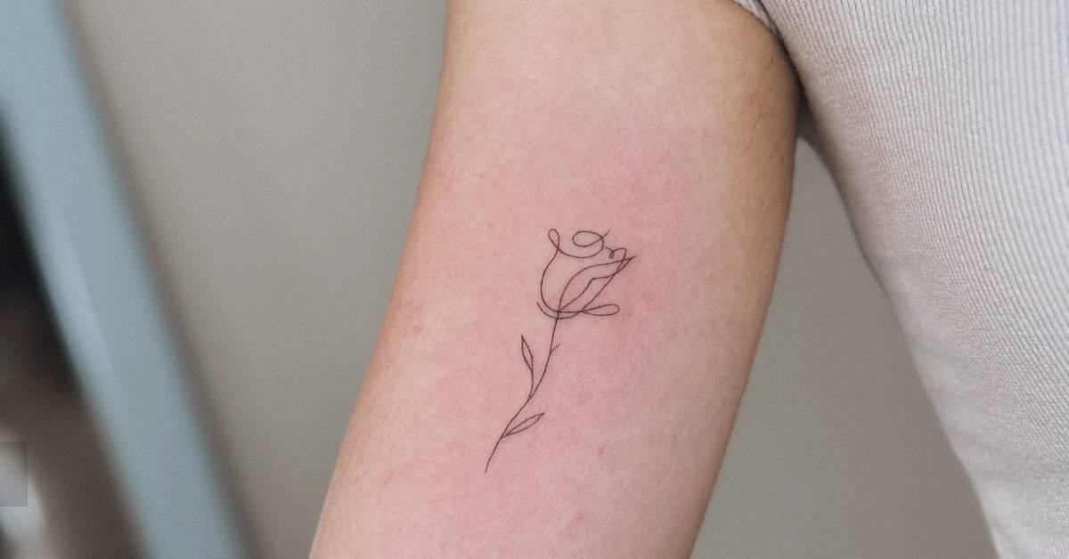 One line rose tattoo located on the inner arm.