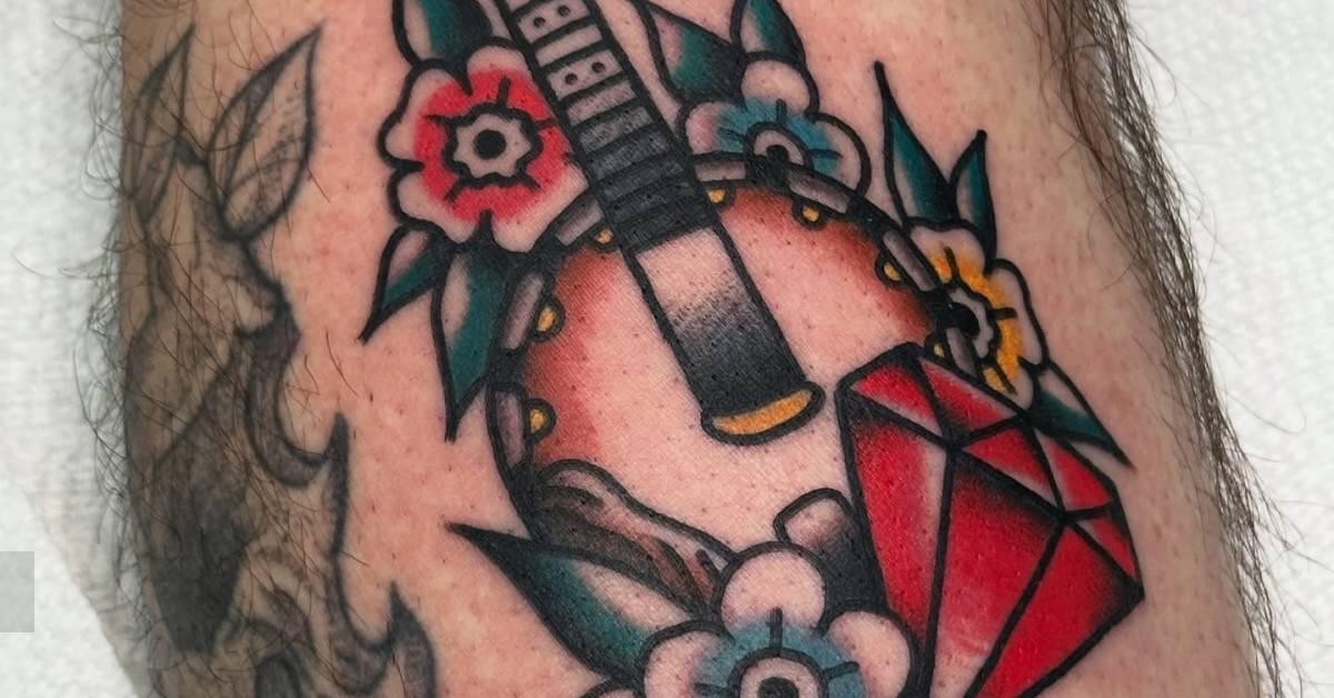 Traditional style banjo tattoo located on the calf.