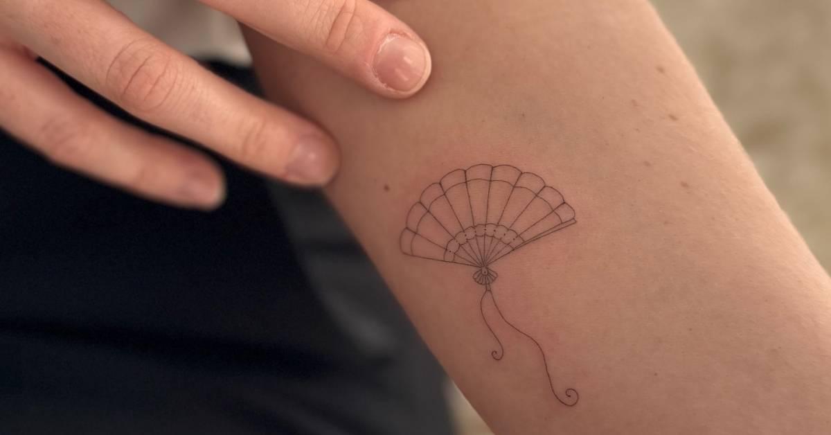 Hand fan tattoo in fine line style located on the inner