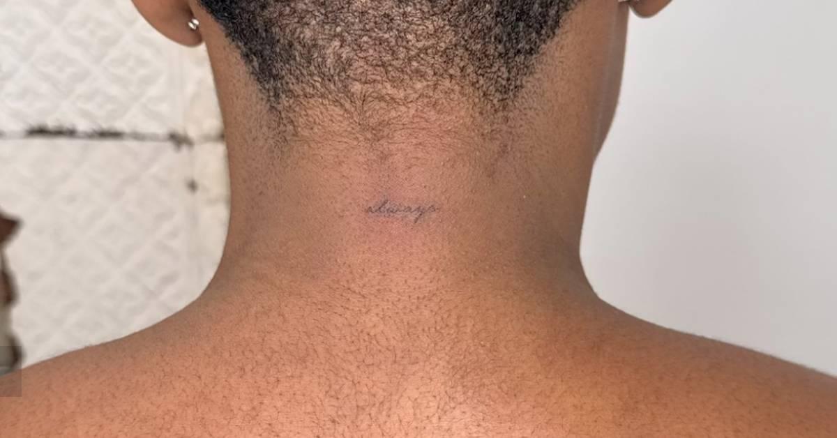 Tiny handwritten lettering tattoo placed on the back of
