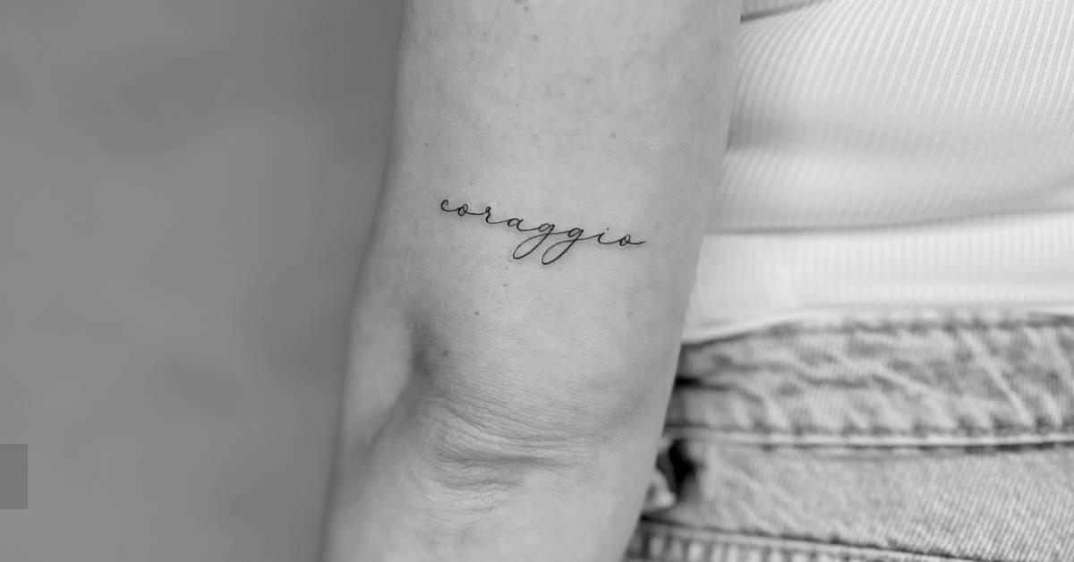 Lettering tattoo of the word "coraggio" located on the