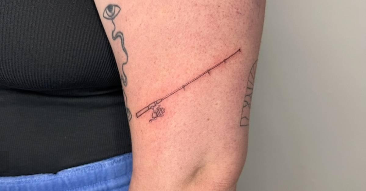 Little fishing rod tattoo in fine line style placed on