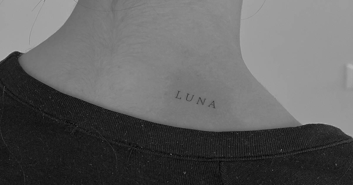 Typewriter font word "luna" tattooed on the upper back.